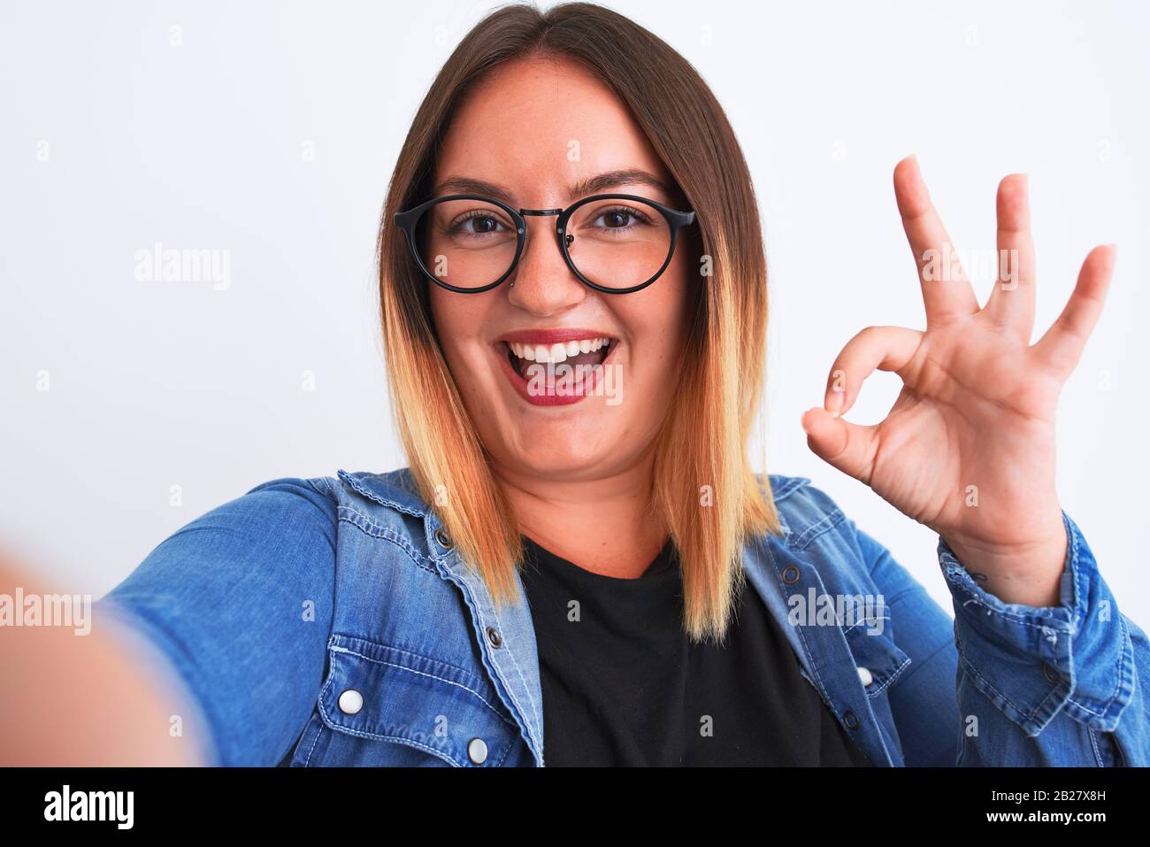 Beautiful woman wearing denim shirt and glasses make selfie over ...