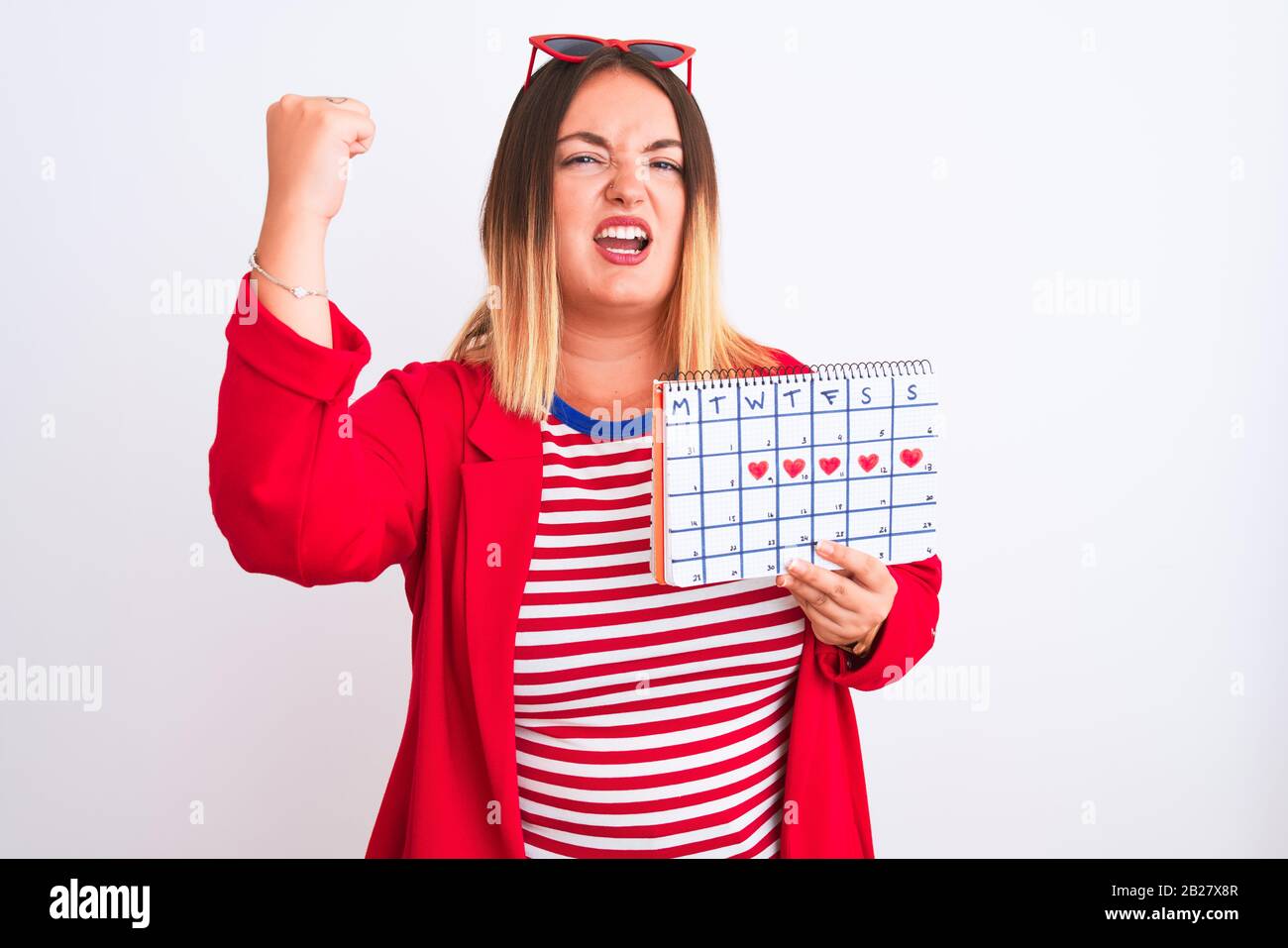 Young beautiful woman holding period calendar standing over isolated ...