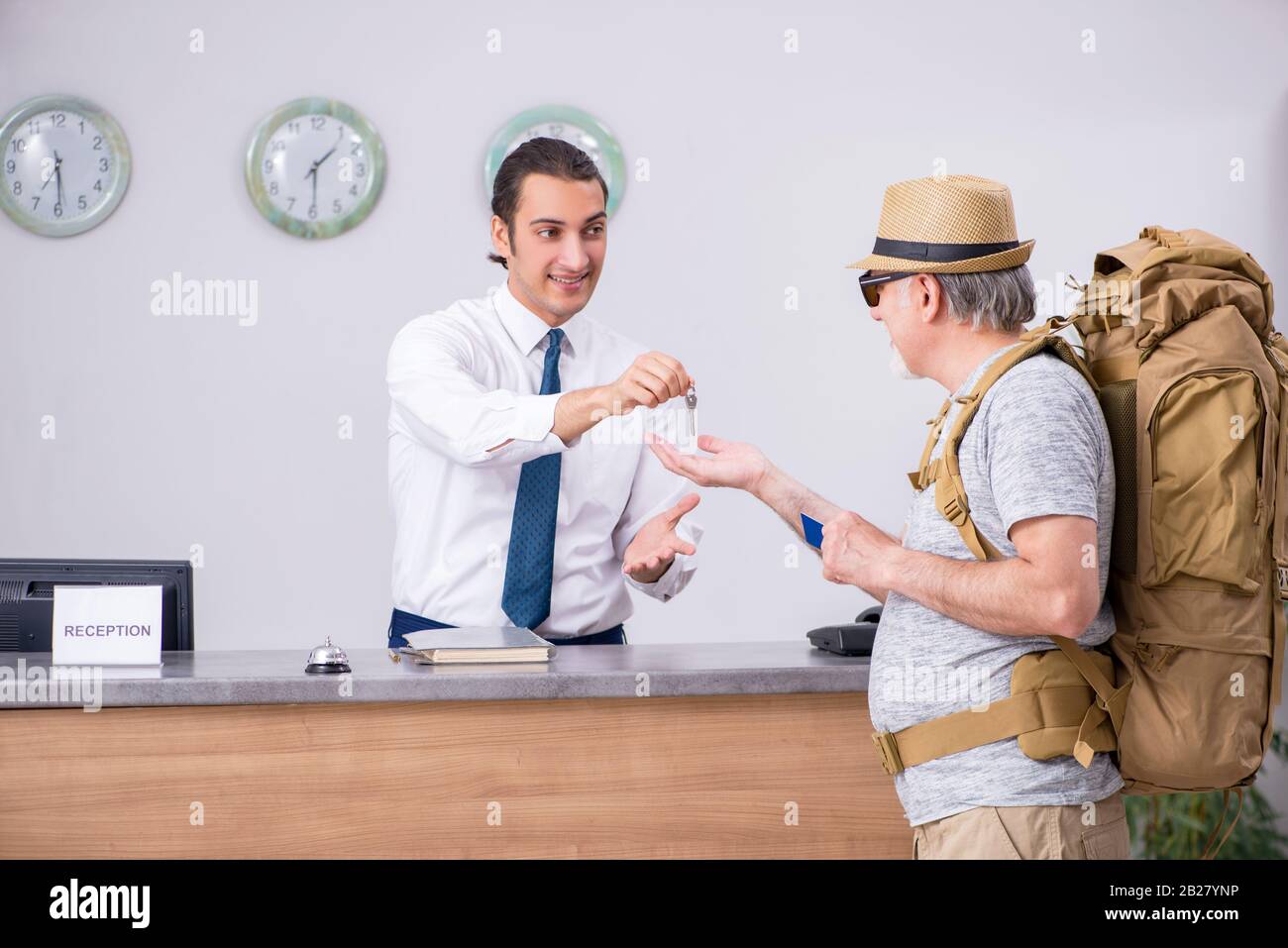 Old backpacker at the hotel reception Stock Photo - Alamy