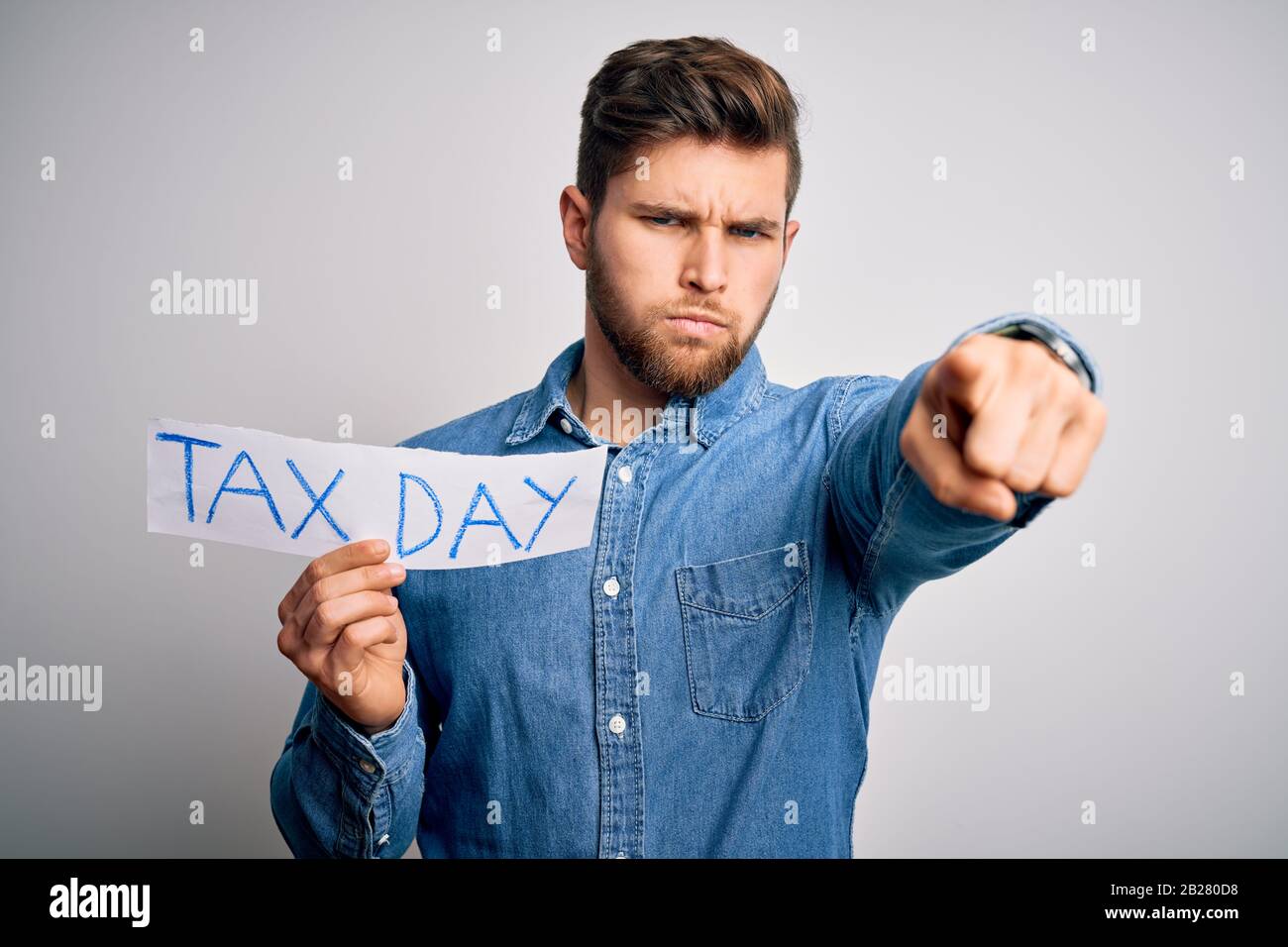 Young blond man with beard and blue eyes holding paper with tax day ...