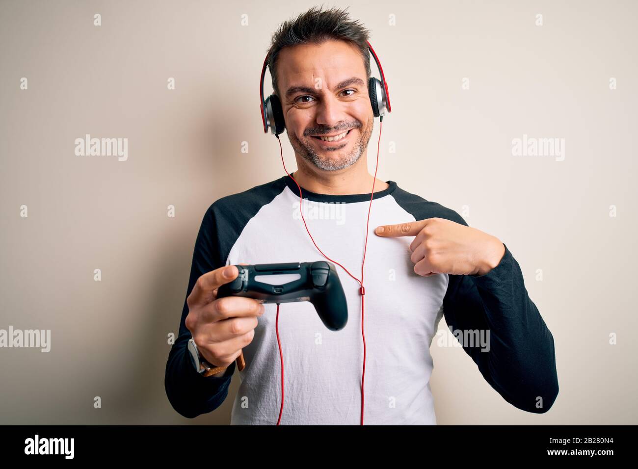 Young handsome gamer man playing video game using joystick and ...