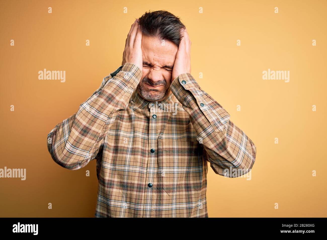 Young handsome man wearing casual shirt standing over isolated yellow ...