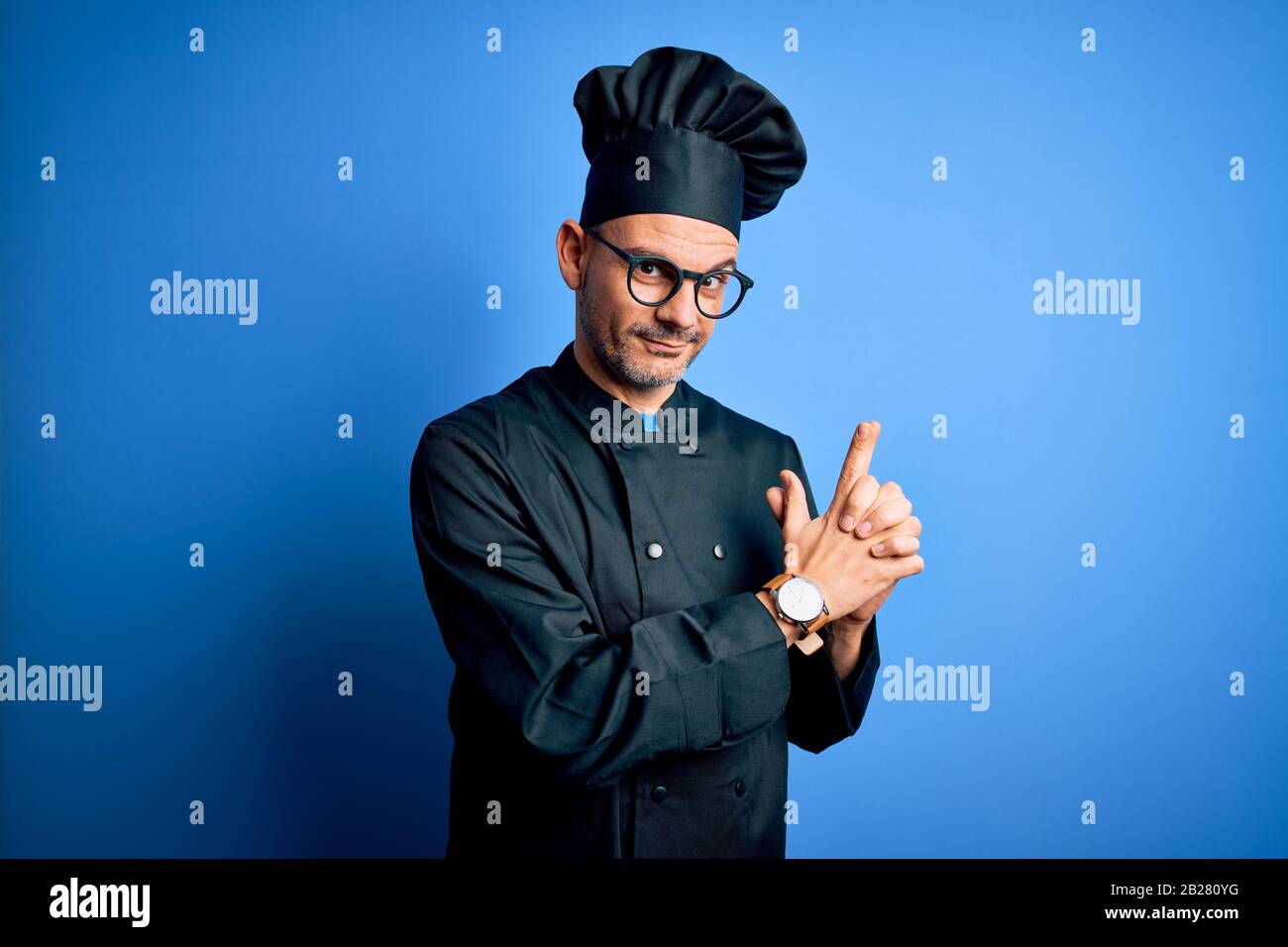 Young handsome chef man wearing cooker uniform and hat over isolated ...