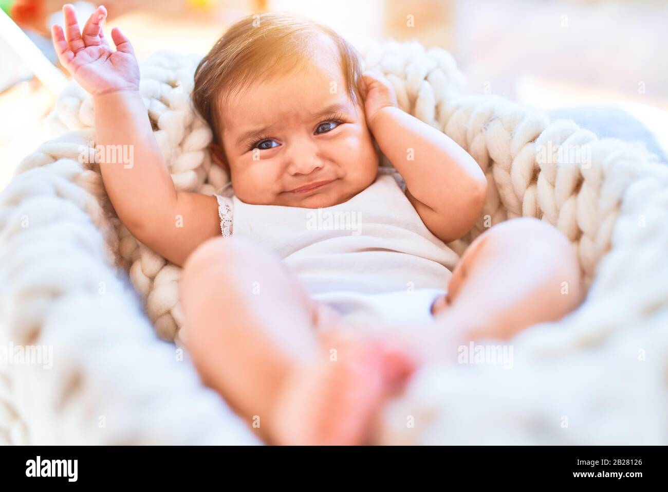 Beautiful infant happy at kindergarten around colorful toys lying ...