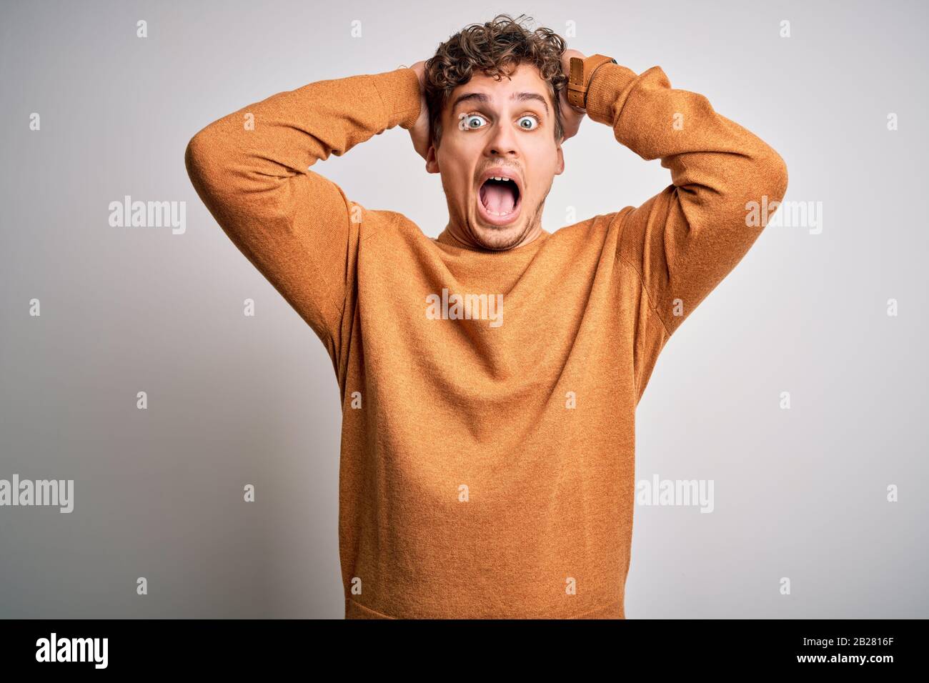 Young blond handsome man with curly hair wearing casual sweater over ...
