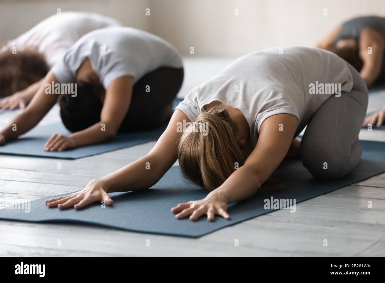Group of people performing Child Pose focus on caucasian girl Stock ...