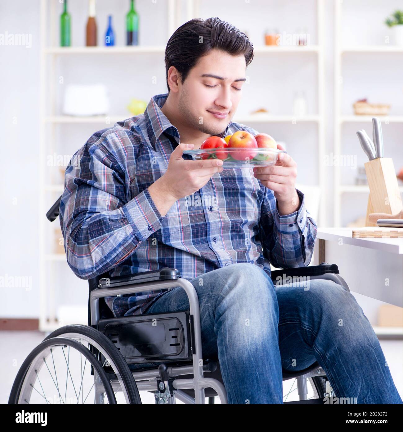 The young disabled husband preparing food salad Stock Photo - Alamy