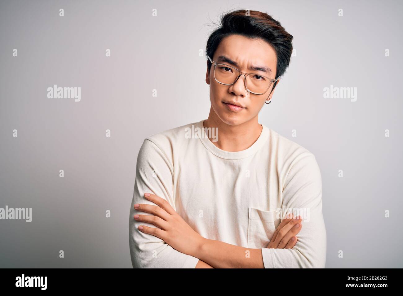 Young handsome chinese man wearing casual t-shirt and glasses over ...