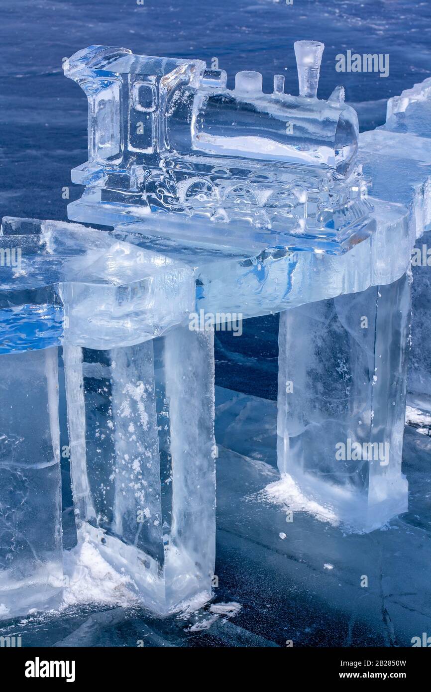 The figure of an old steam locomotive made of ice stands on the ice of ...