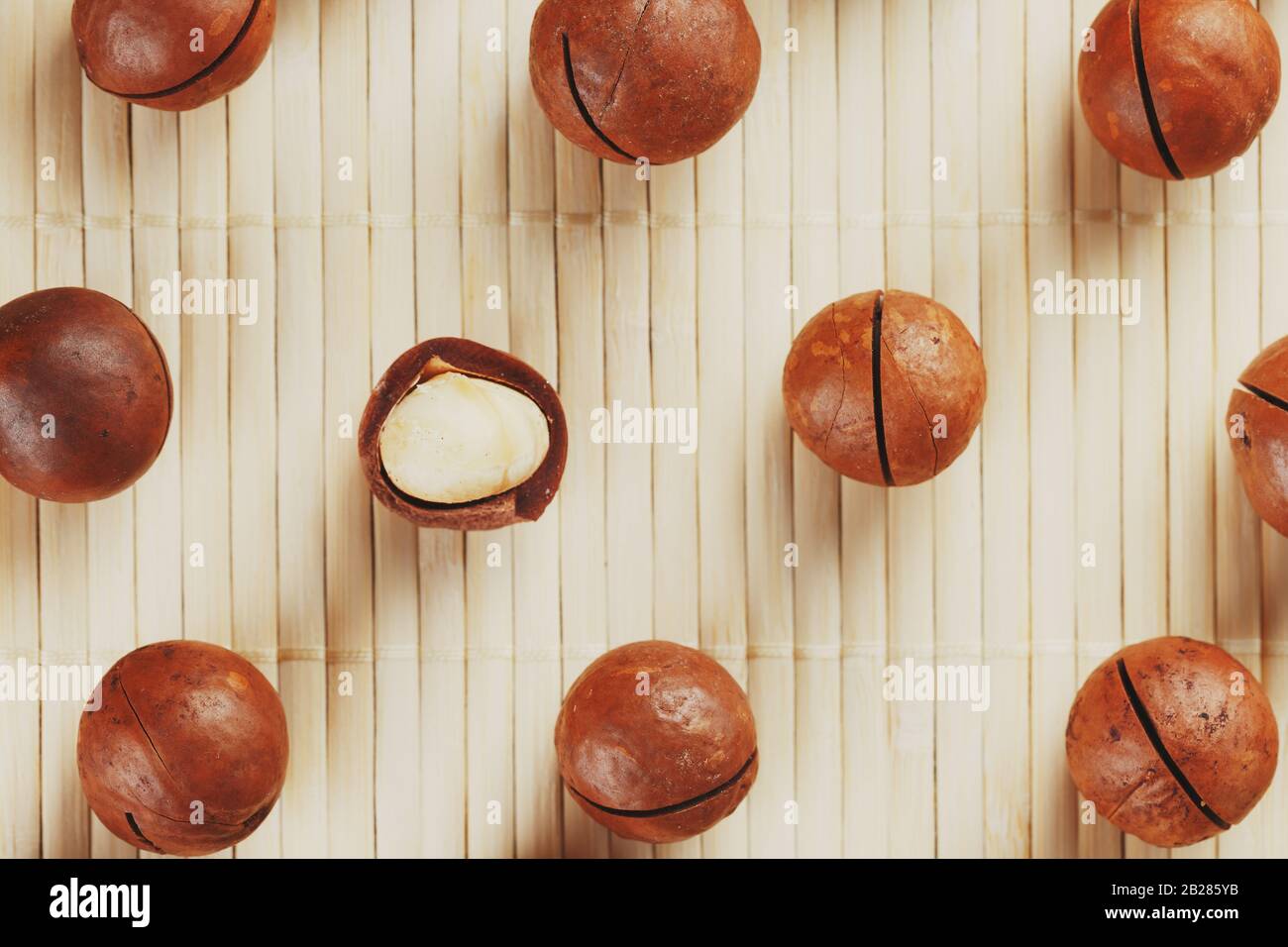 Flat composition with Australian macadamia nuts on bamboo light ...