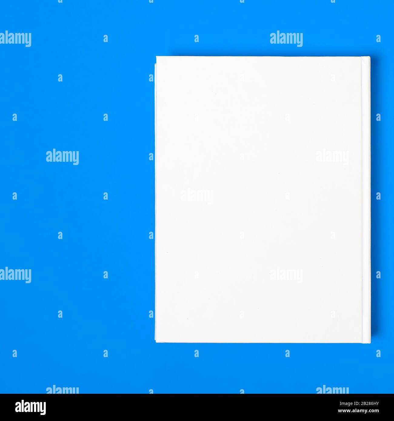 Mockup of closed blank square book at white textured paper background ...