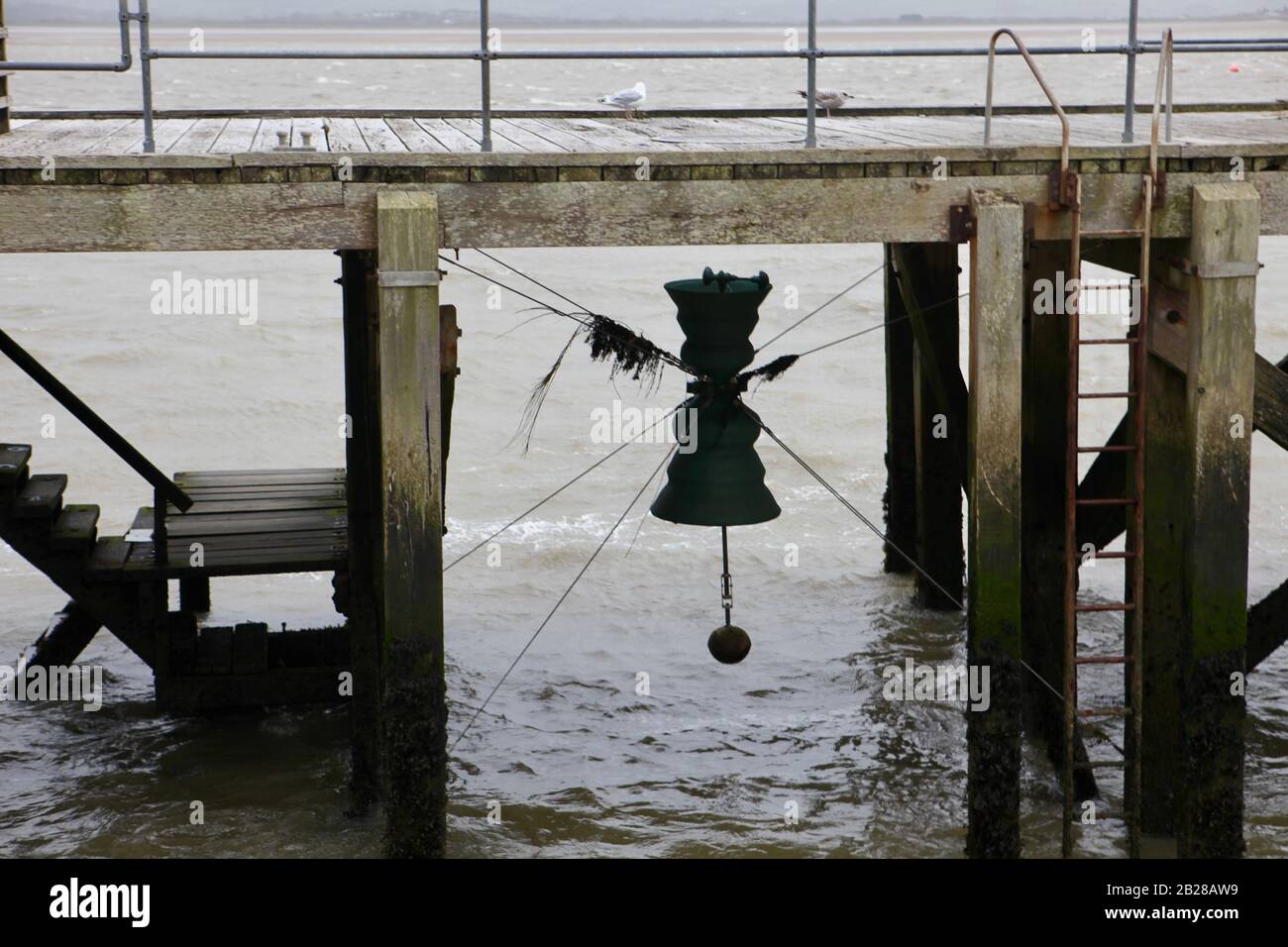 tidal bell mounted underneath pier at Aberdovey, Wales Stock Photo - Alamy
