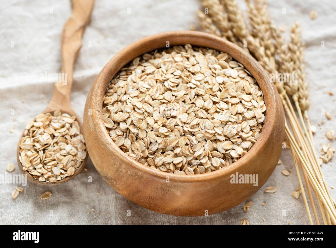 Oat flakes, rolled oats in wooden bowl. Healthy food ingredients, low ...