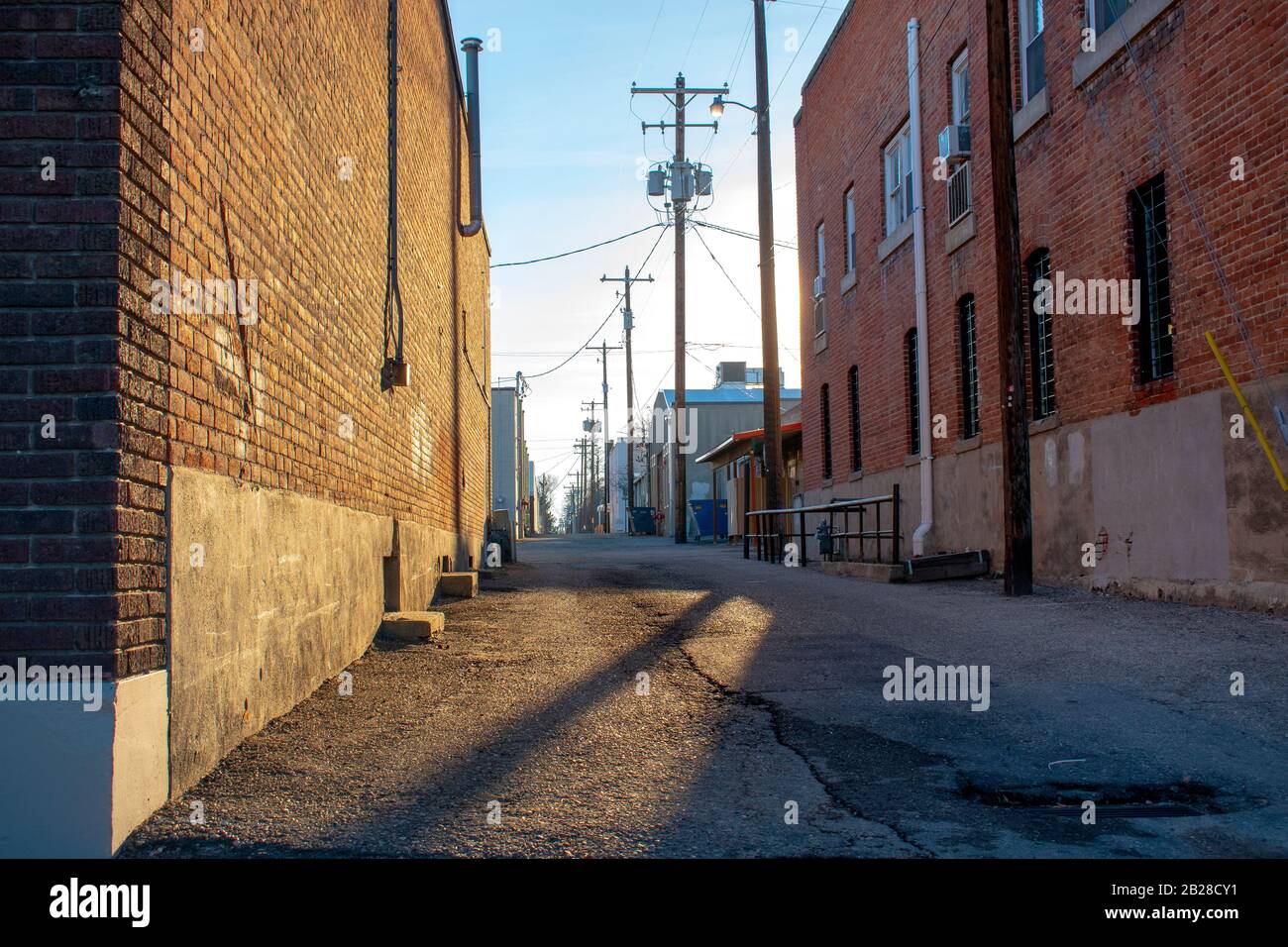 Alleyway between two old downtown buildings with long shadows from the ...