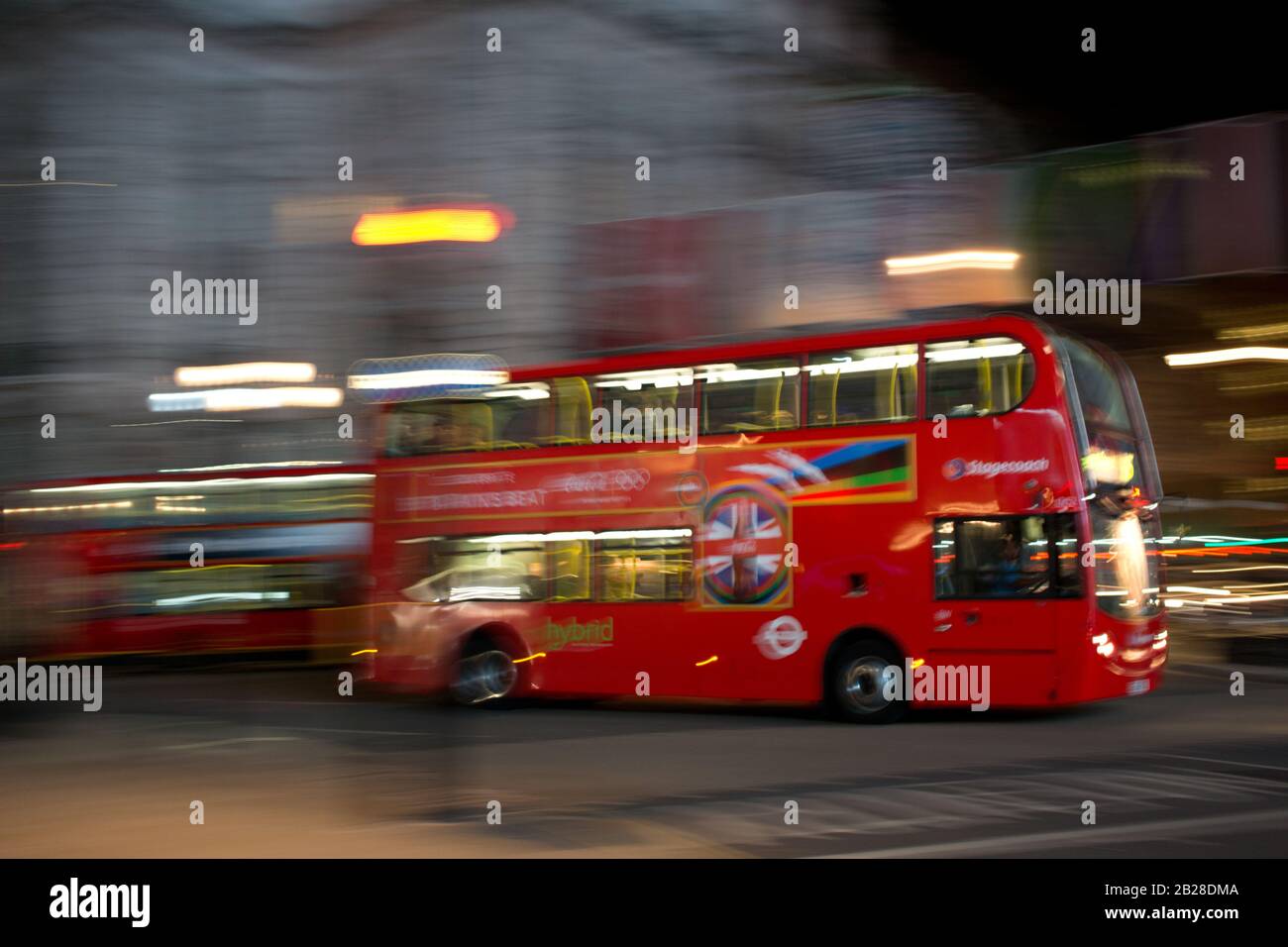 a red doubledeck London bus at night seen with motion blur against ...