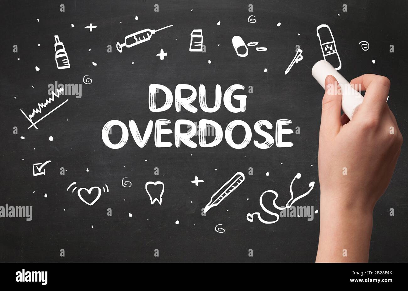 Hand drawing DRUG OVERDOSE inscription with white chalk on blackboard ...
