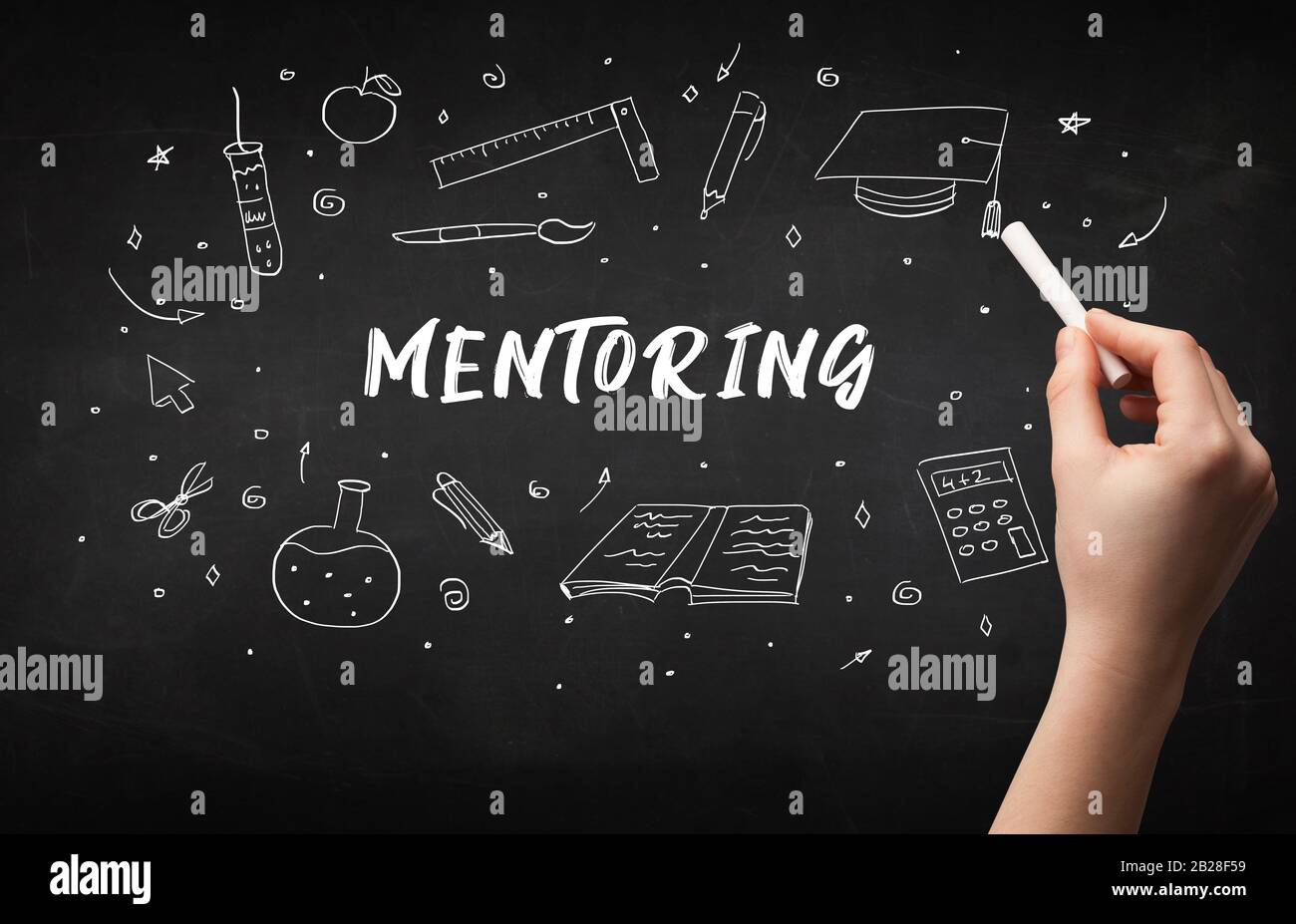 Hand drawing MENTORING inscription with white chalk on blackboard ...