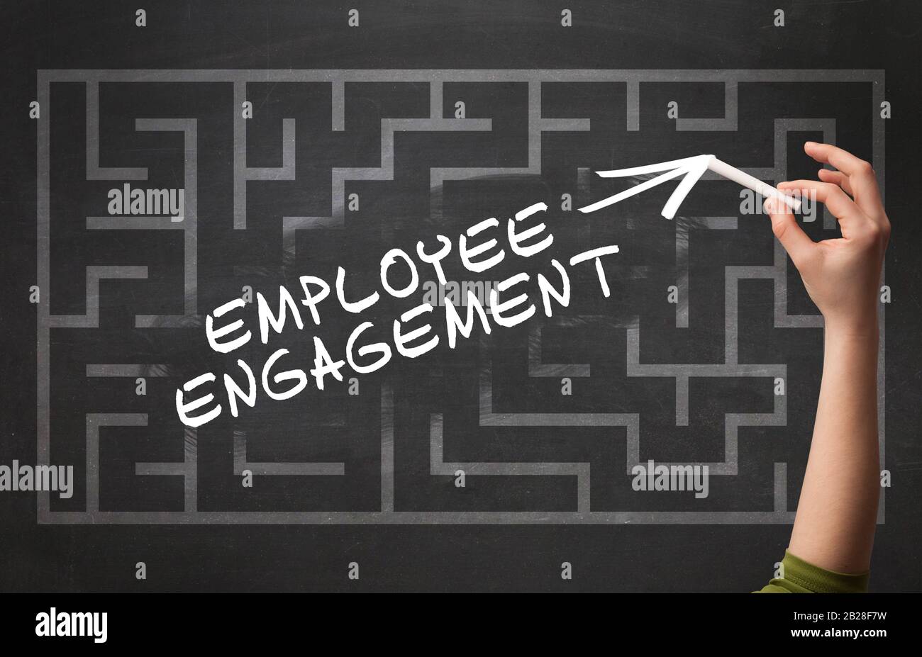 Hand drawing EMPLOYEE ENGAGEMENT inscription with white chalk on ...