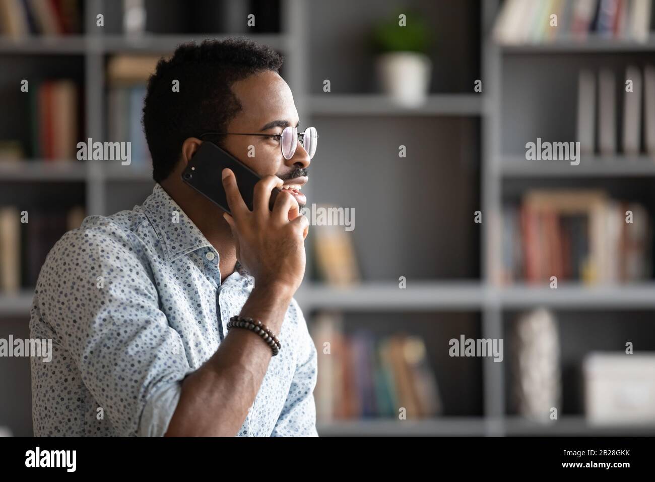 Pleasant handsome biracial man in glasses talking on phone Stock Photo ...
