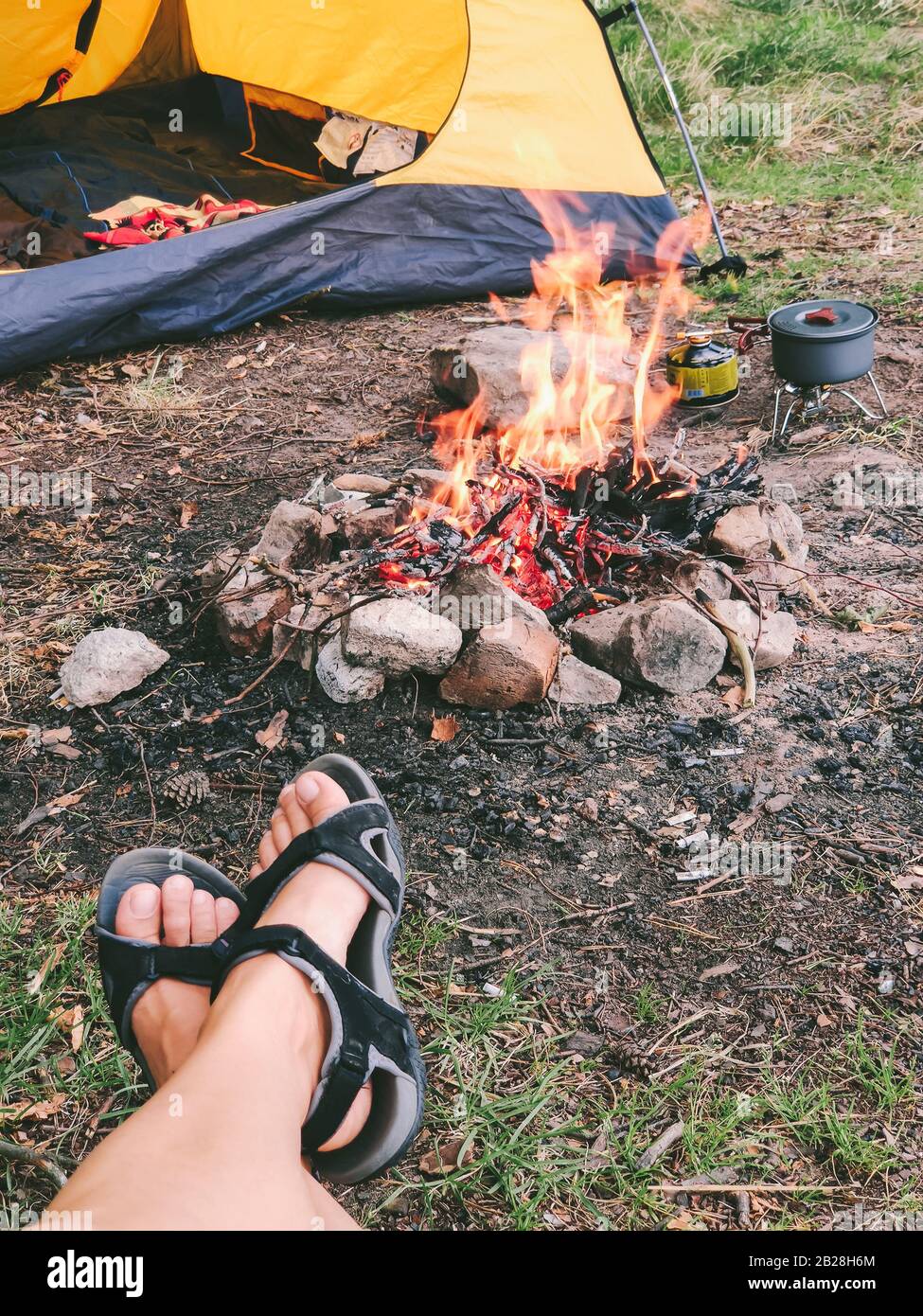 sitting near fire camping concept Stock Photo - Alamy