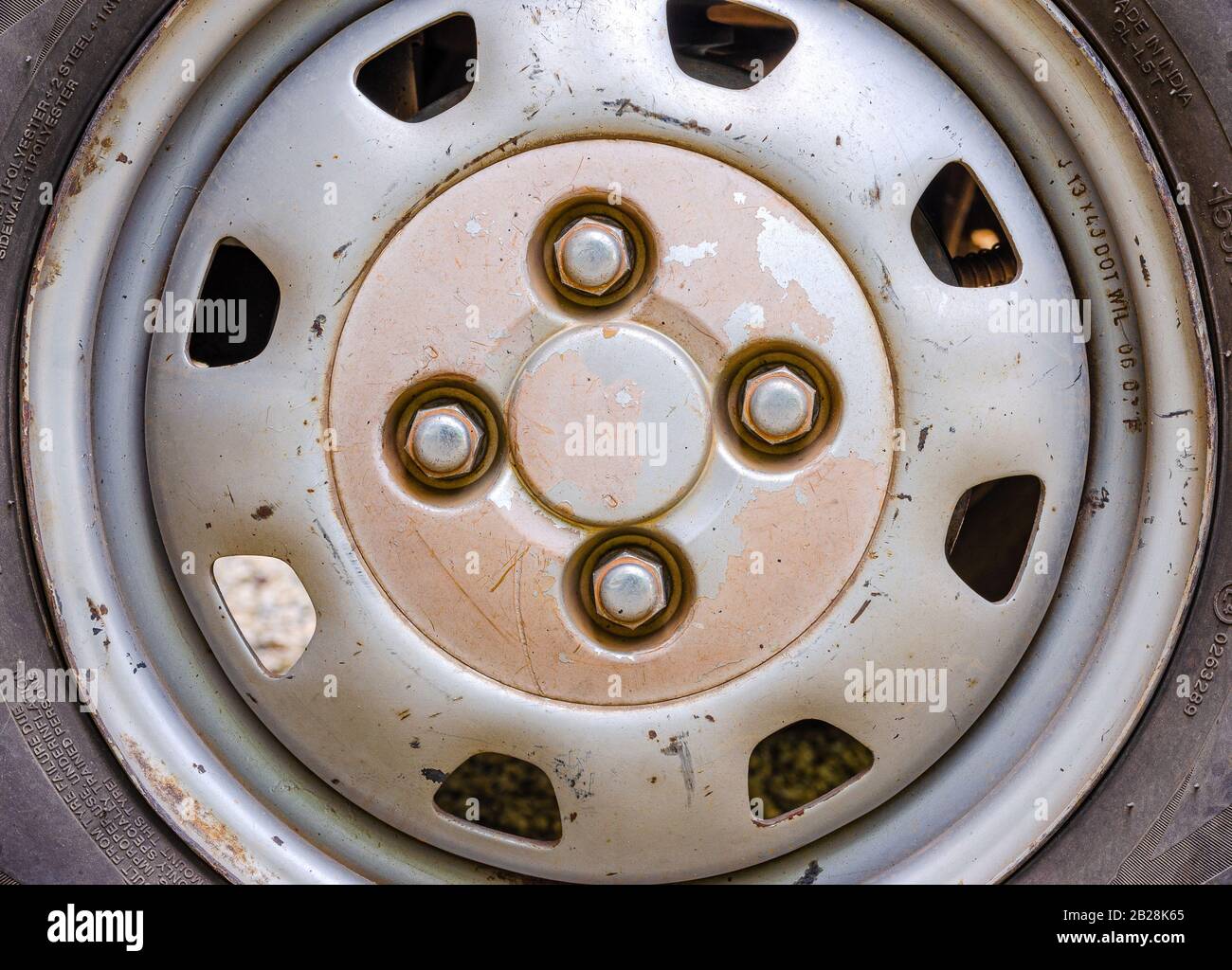 Old, battered car wheel with dents and paint peeling off Stock Photo ...