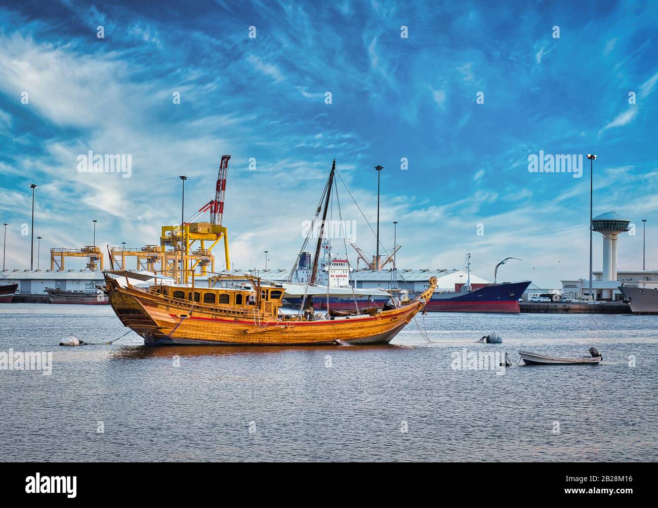 Traditional Omani Dhow anchored at the port along with the modern ships ...