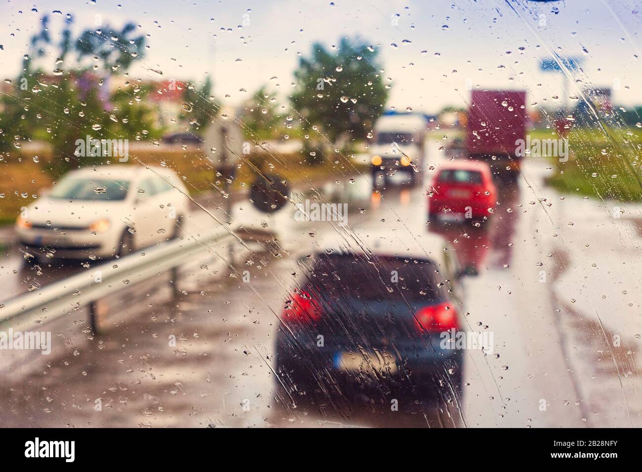raining on the window of car. cars on the road, transportation concept ...
