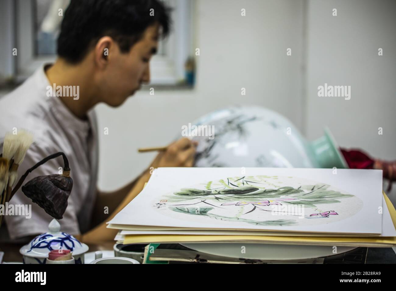 BEIJING, СHINA - JUNE 03: Chinese craftsman paints a large porcelain ...