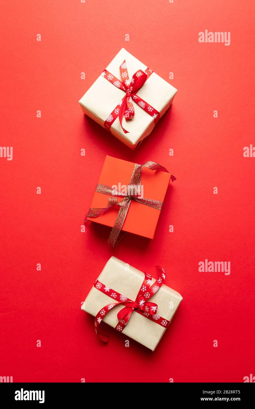 Red and white craft paper gift boxes on red background. Concept of ...