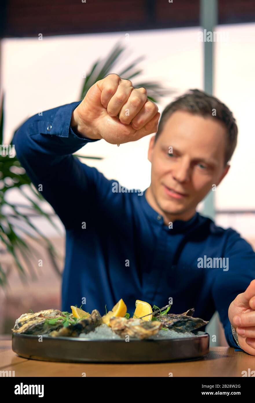 man eating oysters at the table Stock Photo - Alamy