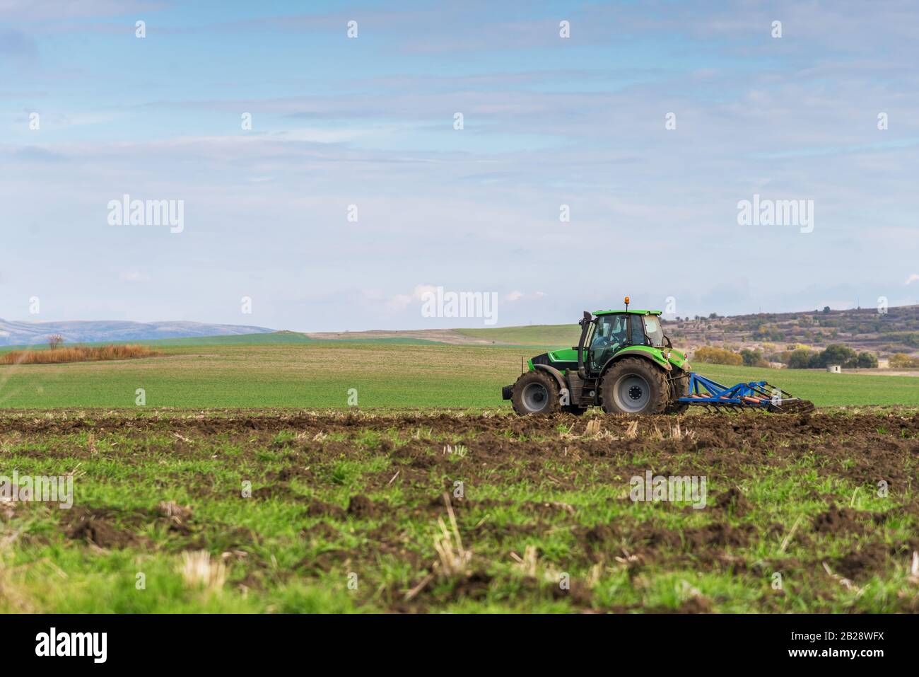 Farmer in tractor preparing land with seedbed cultivator Stock Photo ...