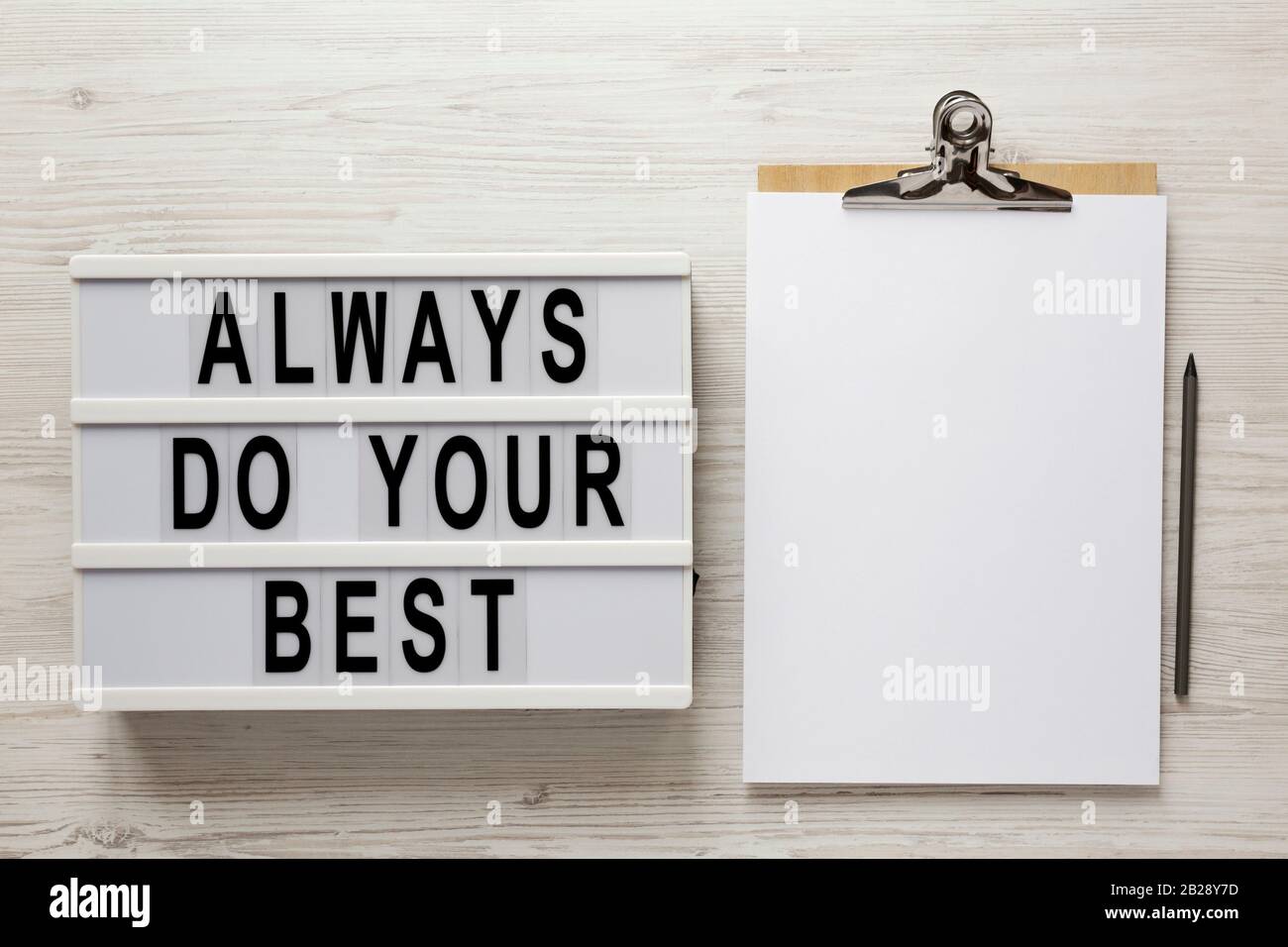 'Always do your best' words on a lightbox, clipboard with blank sheet ...