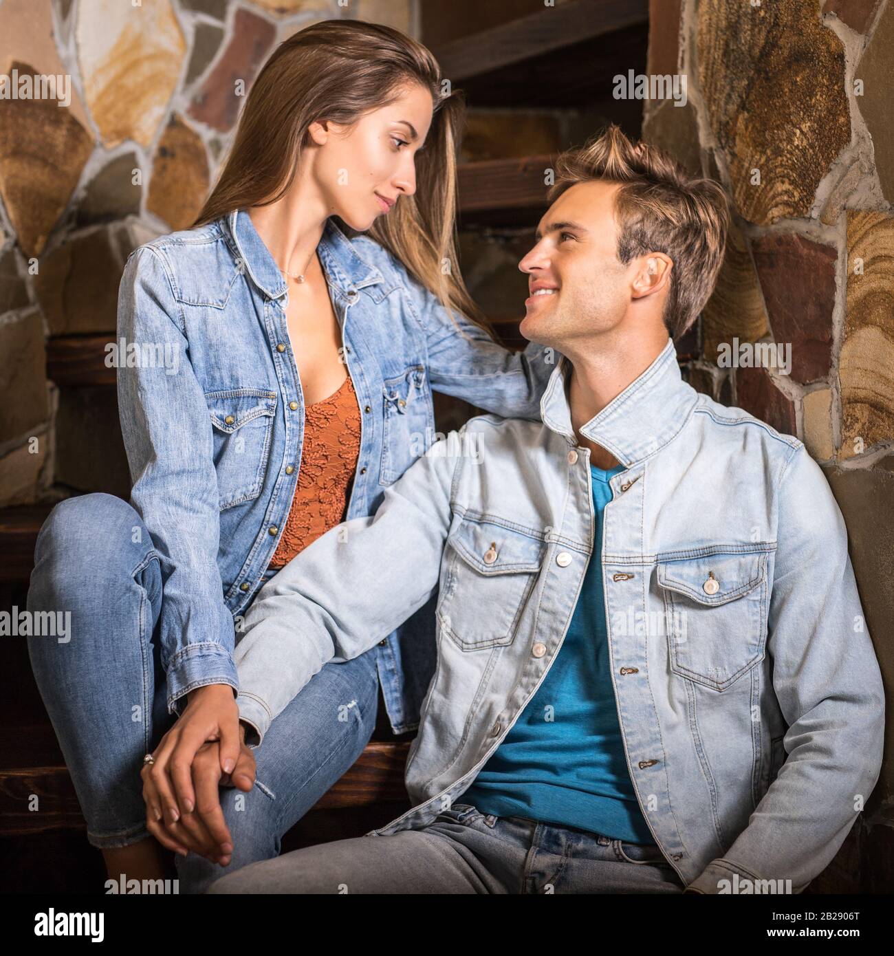 Young and beautiful happy family together in modern wooden house ...