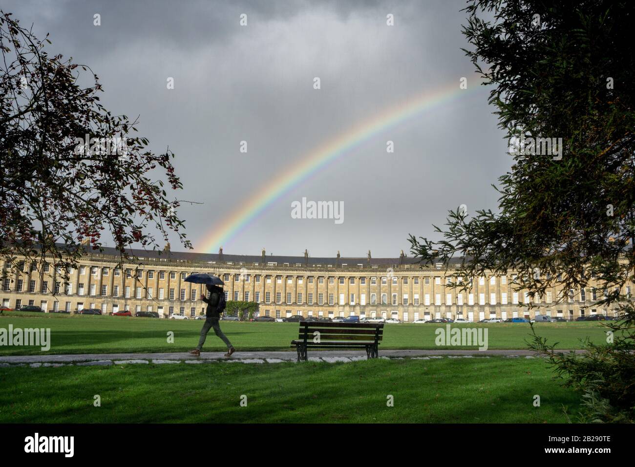 Bath, UK. 1st March 2020. A person braves heavy wintry rain showers at ...