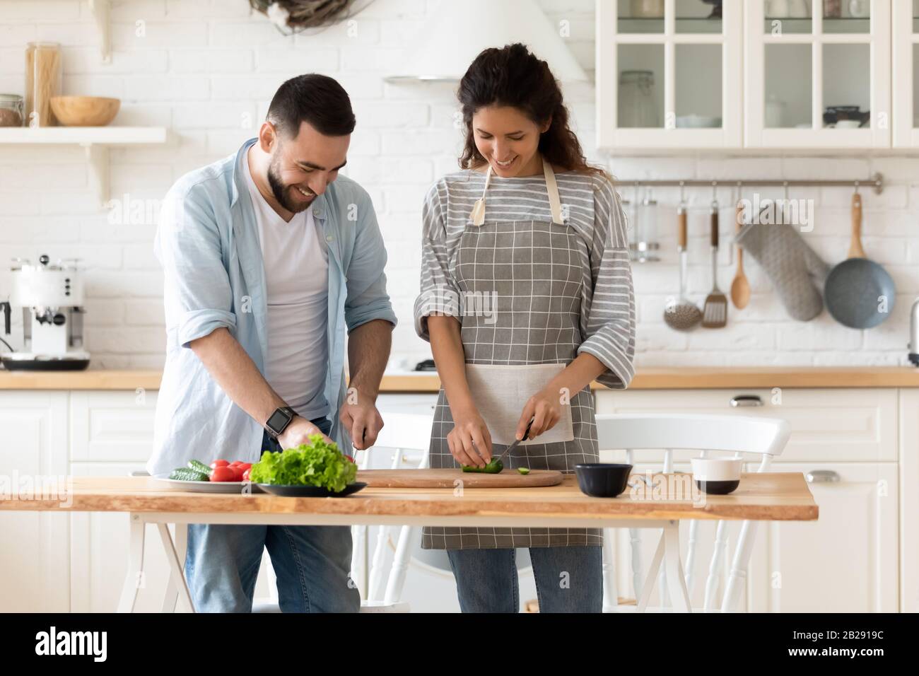 Happy young couple cooking in modern kitchen together Stock Photo - Alamy