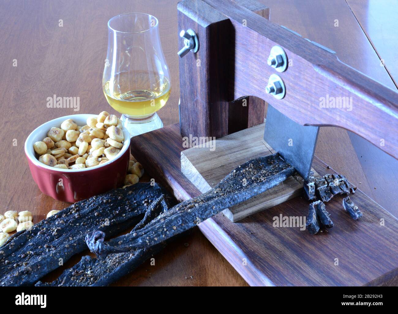 Biltong being cut in a biltong cutter with a cup of toasted corn and a ...