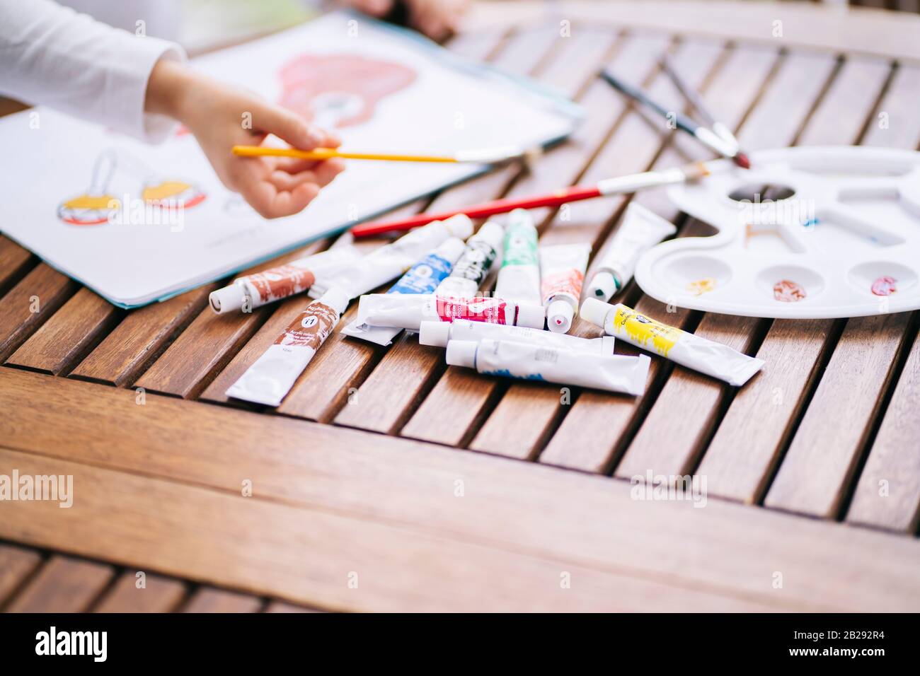 Closeup detail of watercolor paints and a color palette on a wooden ...