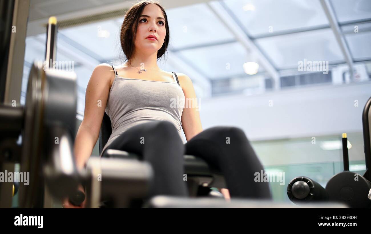 Gym seated leg curl machine exercise woman in the gym Stock Photo - Alamy