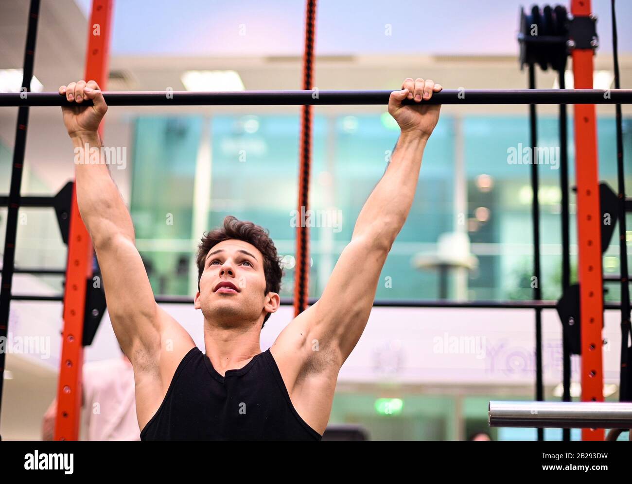 Man doing free body calisthenic pull-ups to traing his back and ...