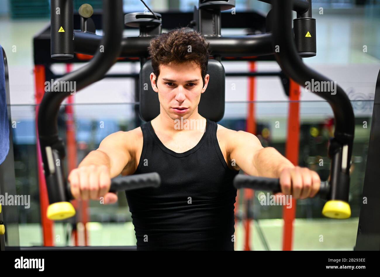 Man using a chest press machine in a gym Stock Photo - Alamy