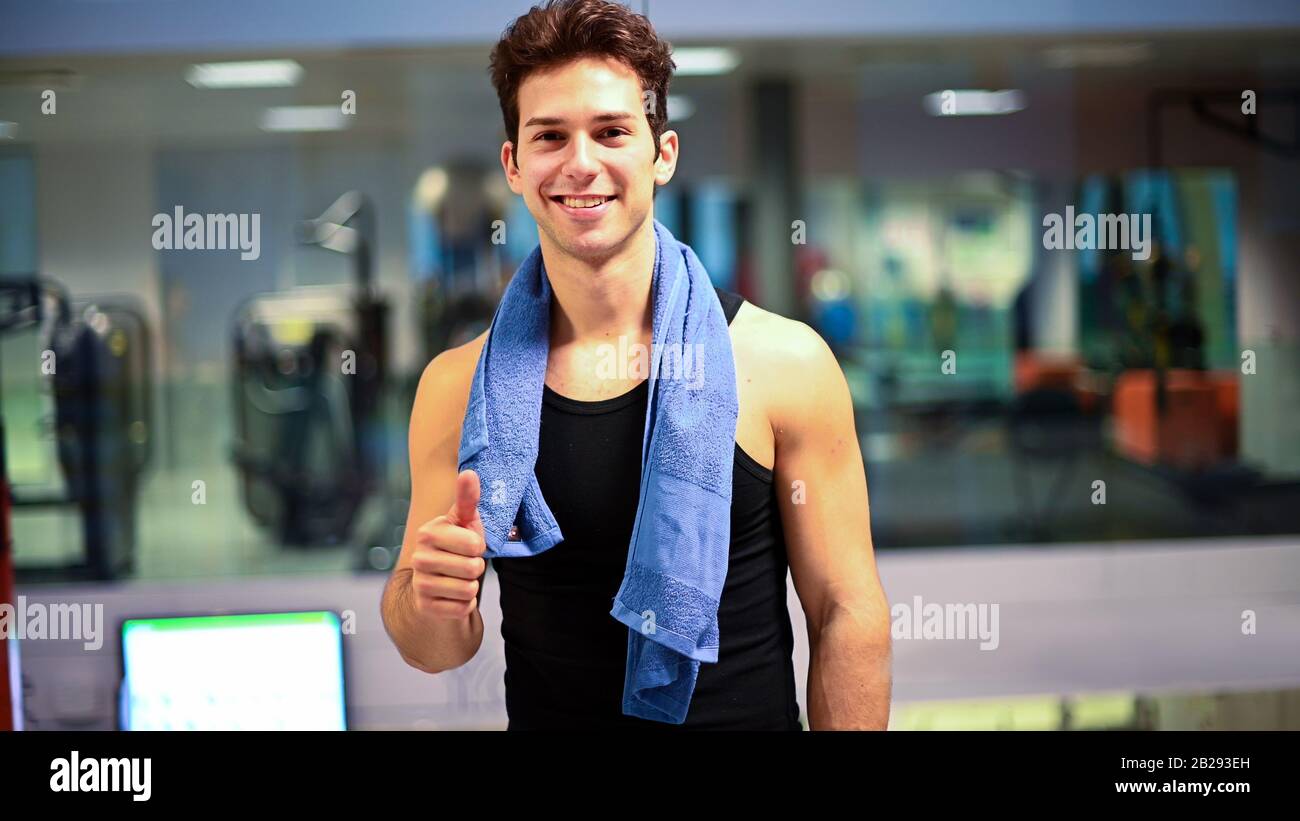 Smiling personal trainer in the gym giving thumbs up Stock Photo - Alamy