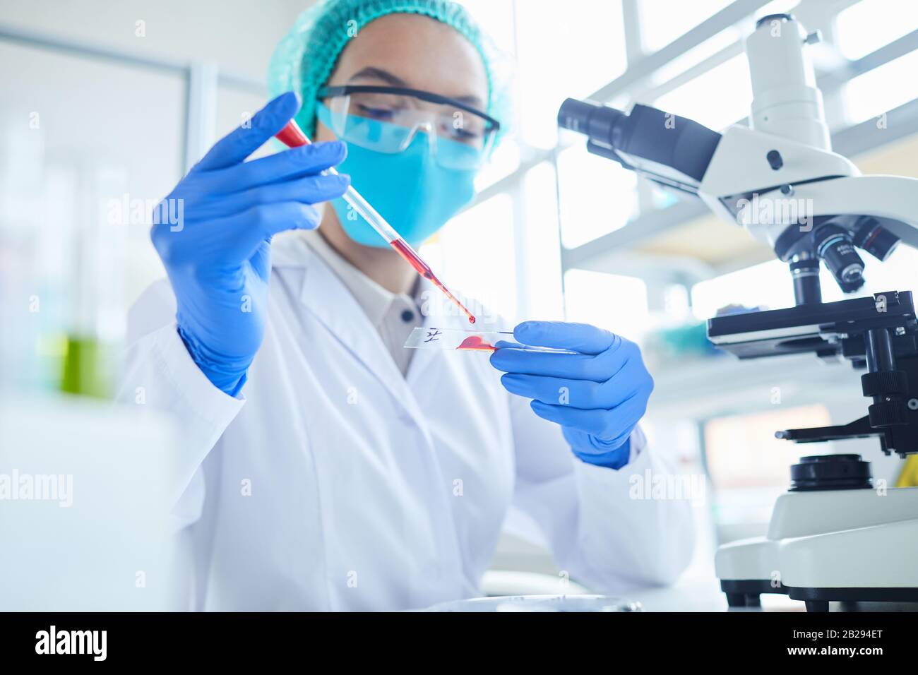 Low angle view at female scientist performing blood test while working ...