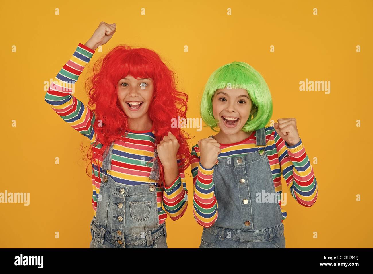 Being happy. Happy children make victory gestures yellow background ...