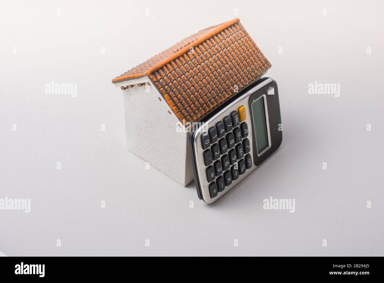 Model house and calculator placed on white background Stock Photo - Alamy