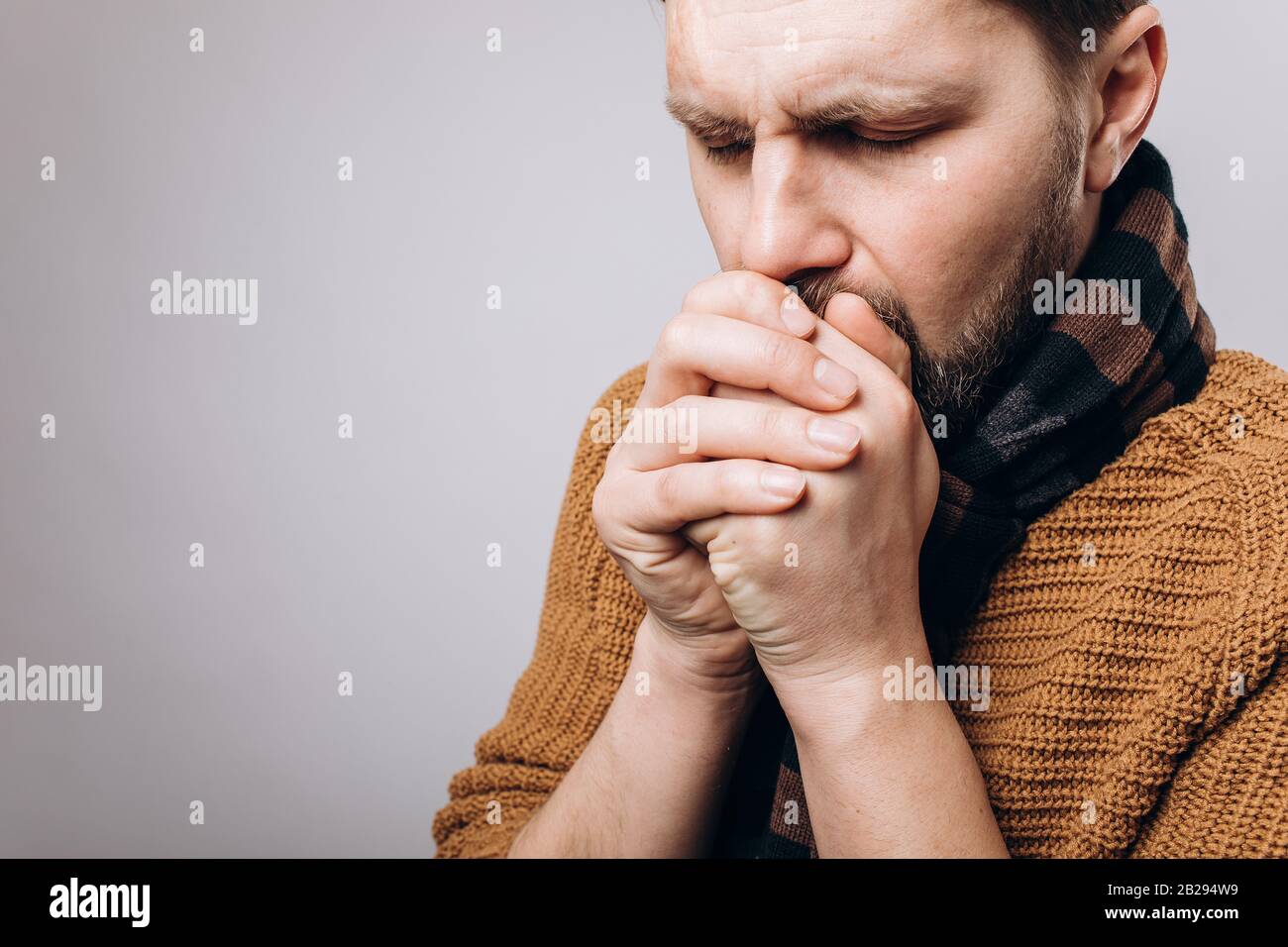 Close up of middle-aged sick person covering his mouth with hands while ...