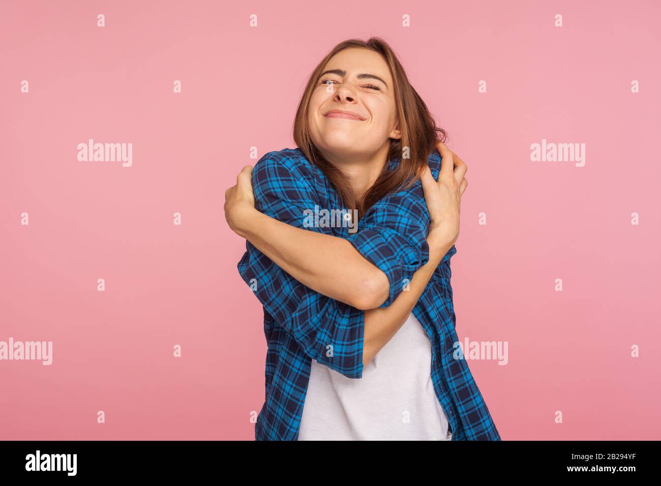 I love myself! Portrait of charming girl in checkered shirt hugging ...