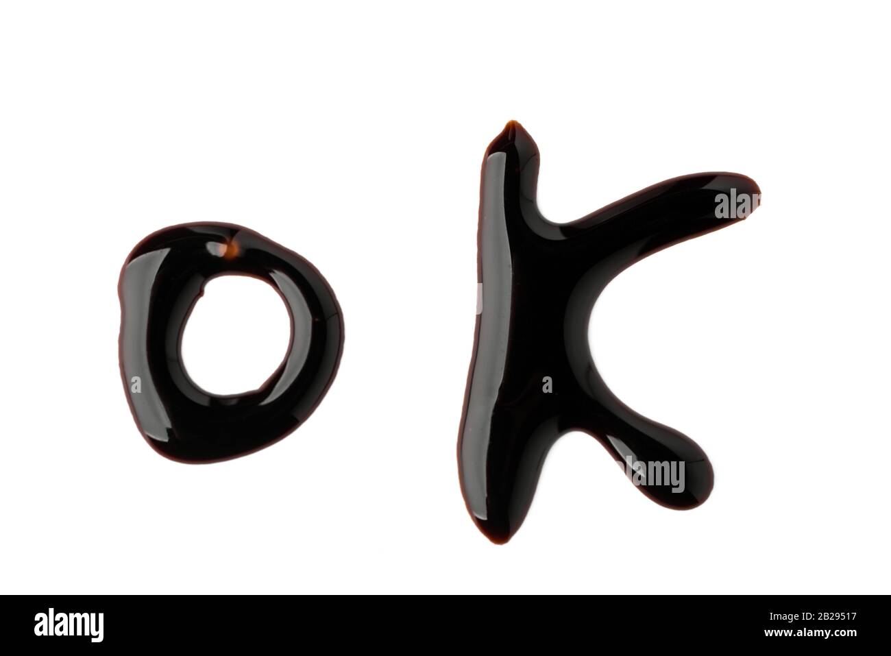 OK lettering made with chocolate syrup and isolated on white background ...