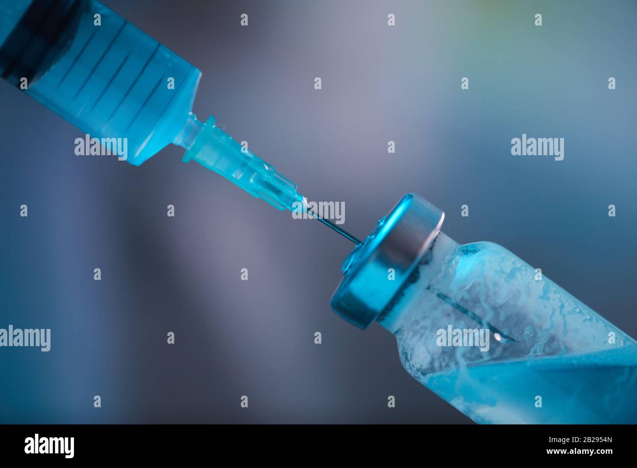 Extreme closeup of syringe needle taking medicine from glass vial ...