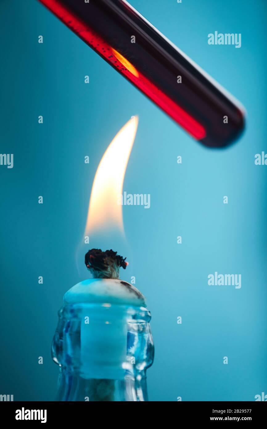 Extreme closeup of blood sample heating over gas fire in medical ...