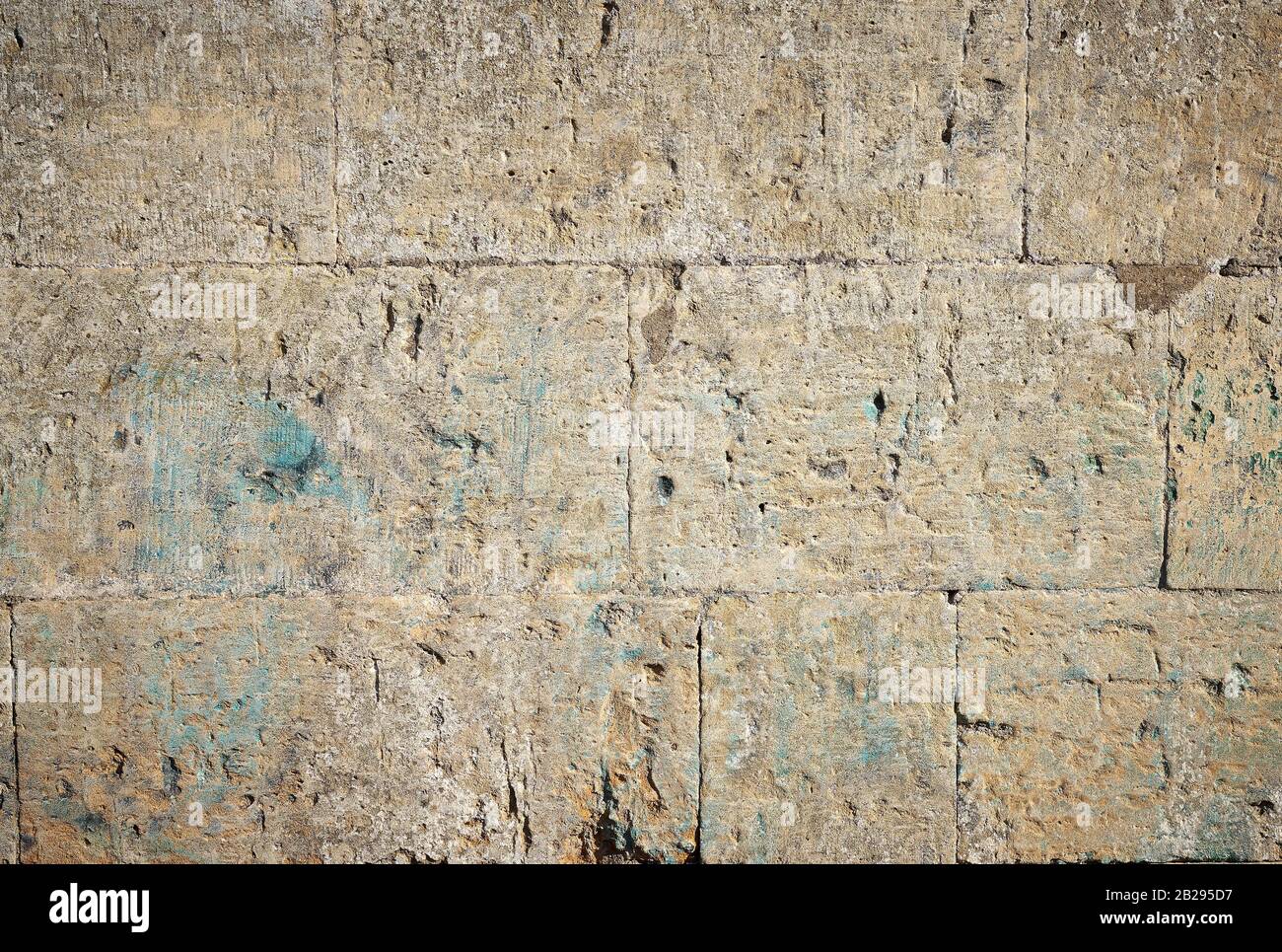 wall of yellow rectangular stones with cement, fragment of ancient ...